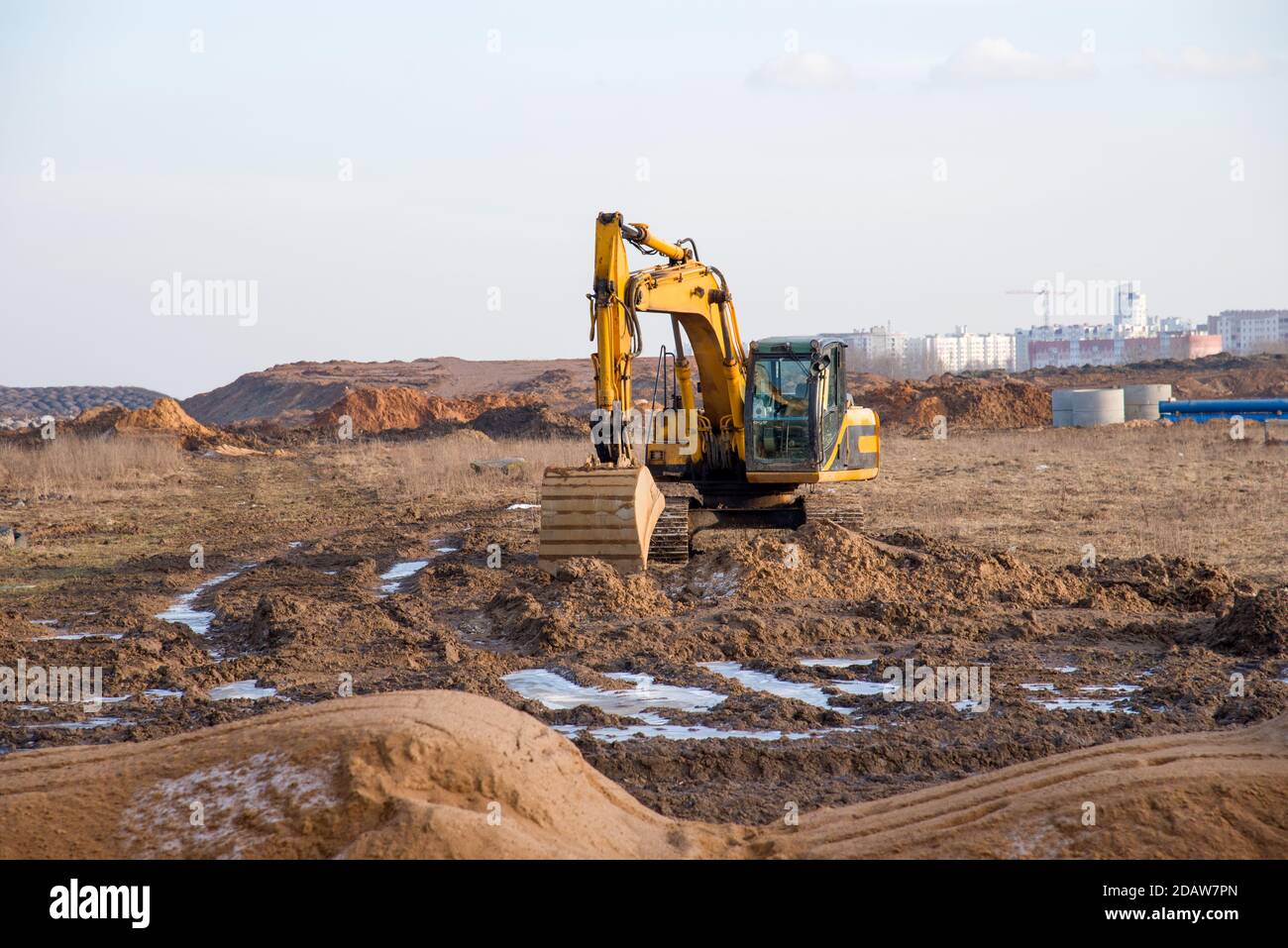 Excavator working at construction site. Backhoe digs ground for the ...