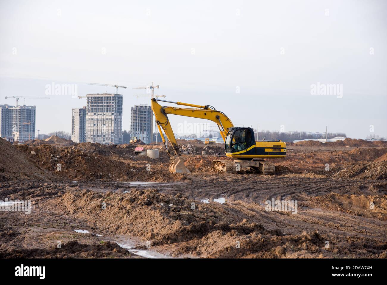 Excavator working at construction site. Backhoe digs ground for the ...