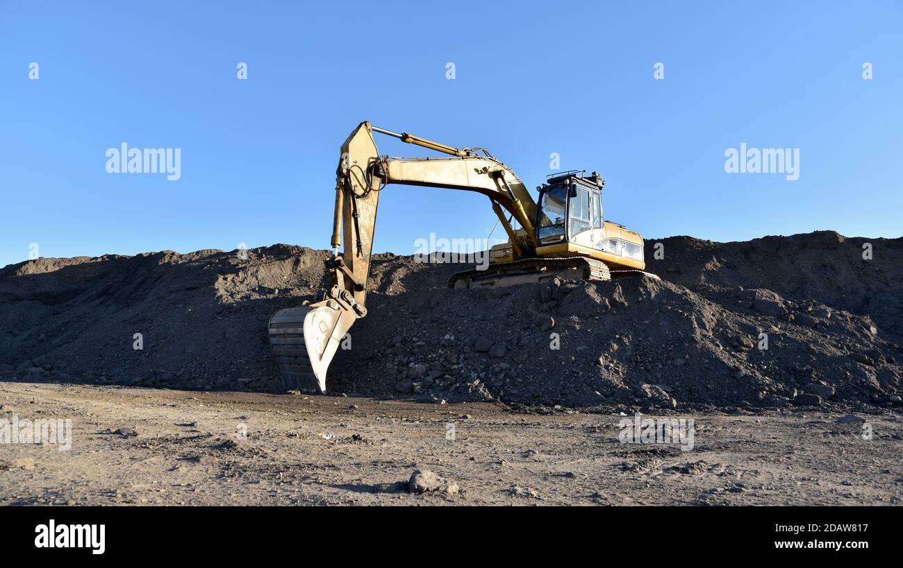 Excavator working at construction site. Backhoe digs ground in sand ...