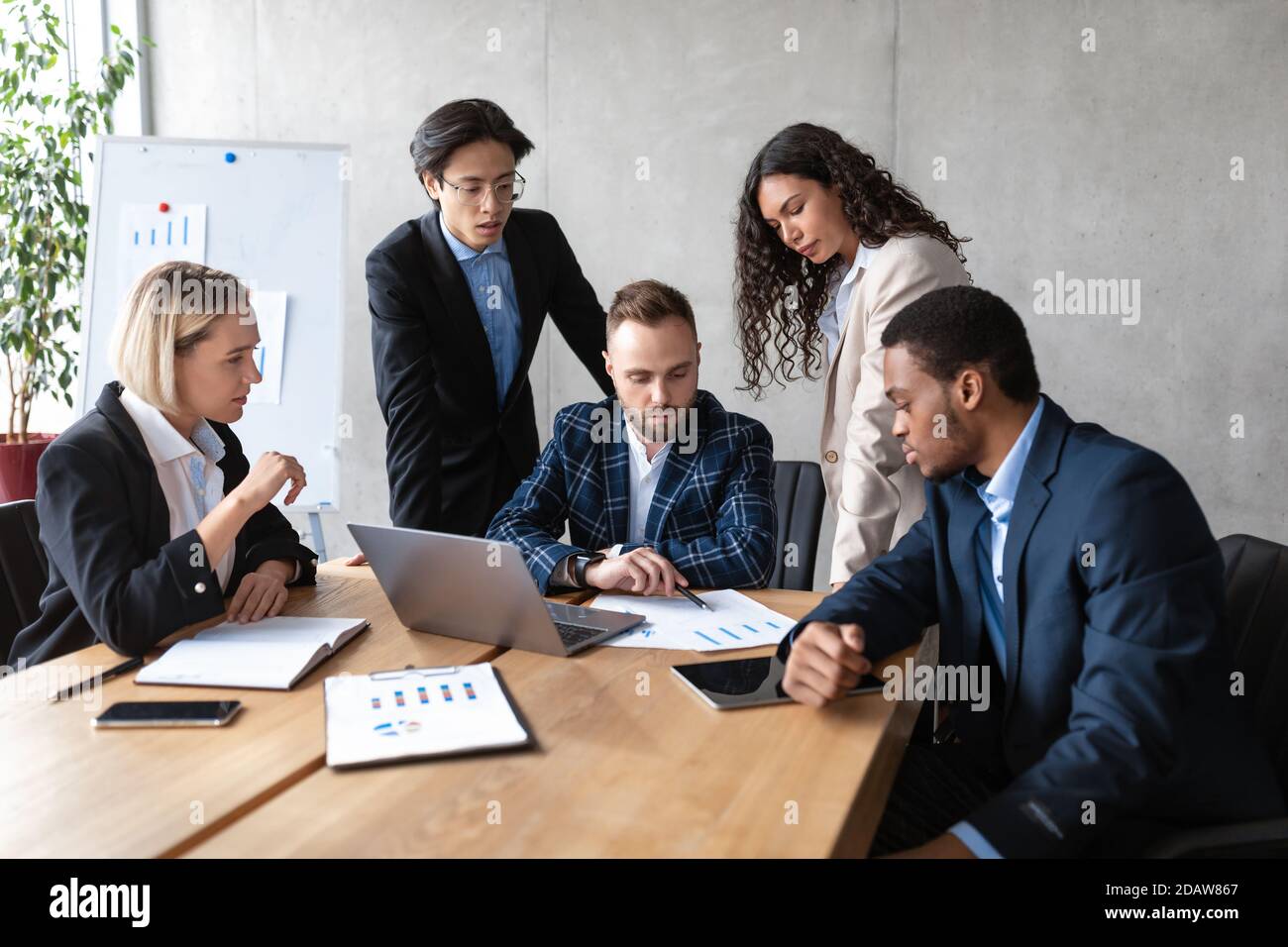 Serious Diverse Business Team Working At Laptop In Office Stock Photo ... Serious Diverse Business Team Working At Laptop In Office Stock Photo ...