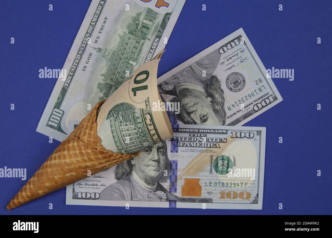 Close up ice cream wafer cone with rolled up american us dollar ...