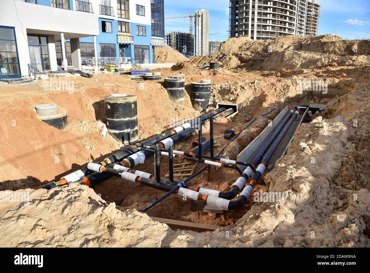 Laying heating pipes in trench at construction site. Installing ...