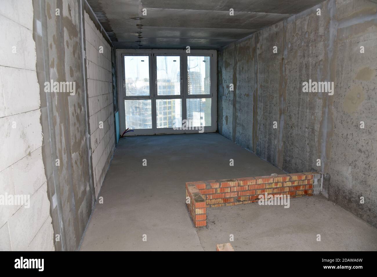 Unfinished interior of apartment under construction with gray concrete ...