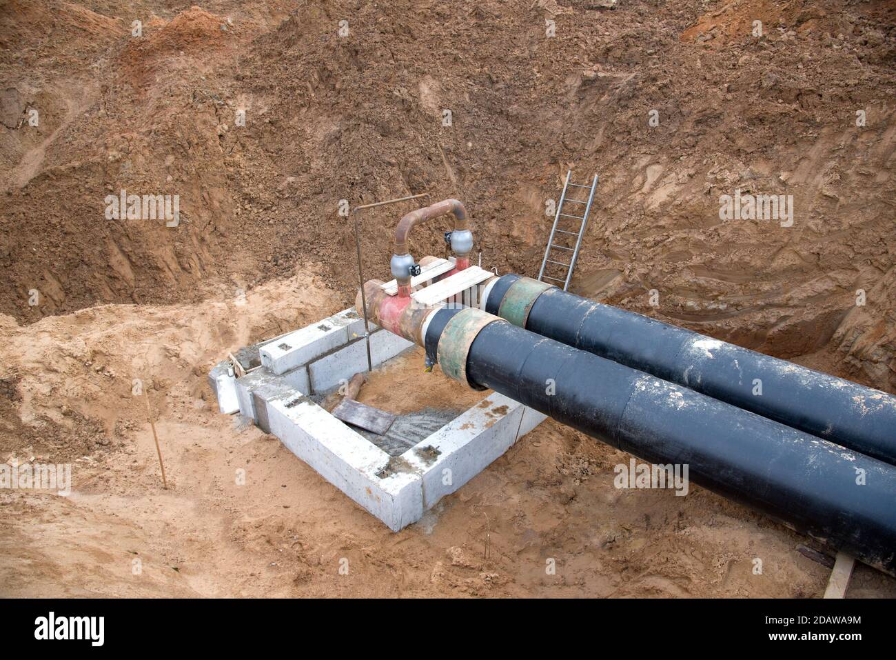Laying heating pipes in a trench at construction site. Installation ...