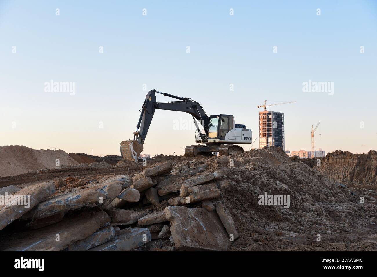 Excavator during earthmoving at construction site. Backhoe digg ground ...