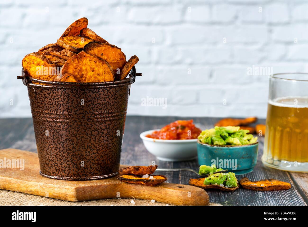 Homemade spiced sweet potato chips with smashed avocado and tomato ...