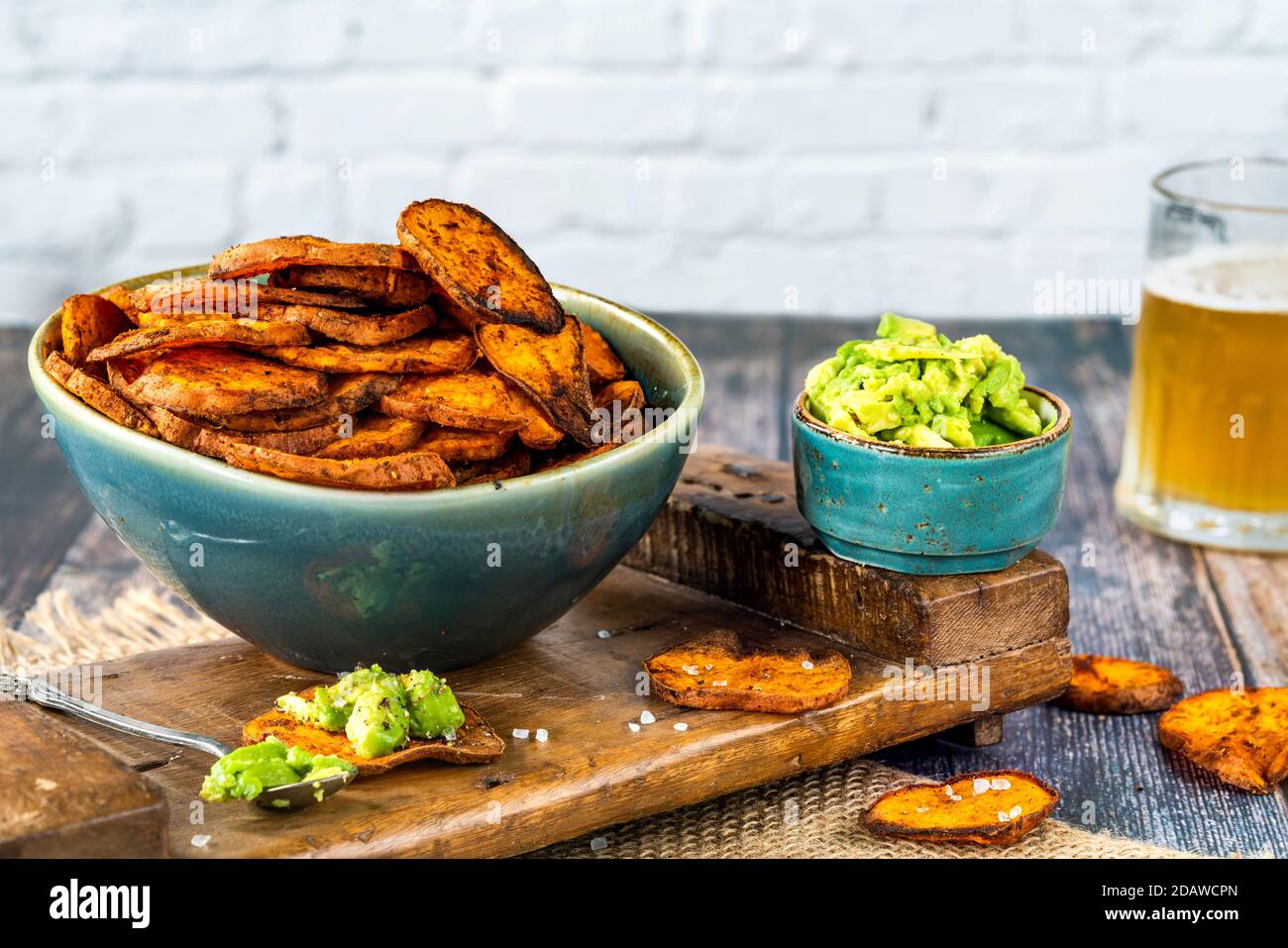 Homemade spiced sweet potato chips with smashed avocado Stock Photo - Alamy