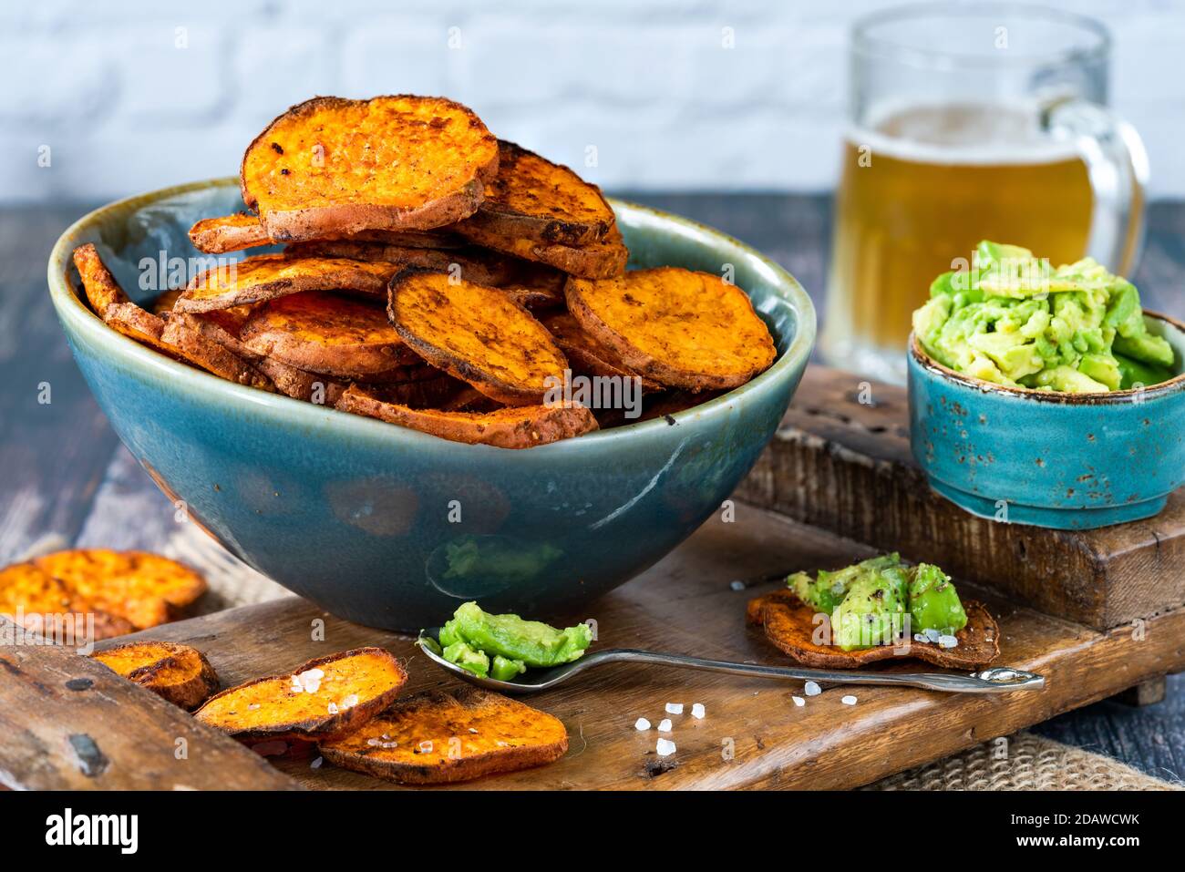 Homemade spiced sweet potato chips with smashed avocado Stock Photo - Alamy