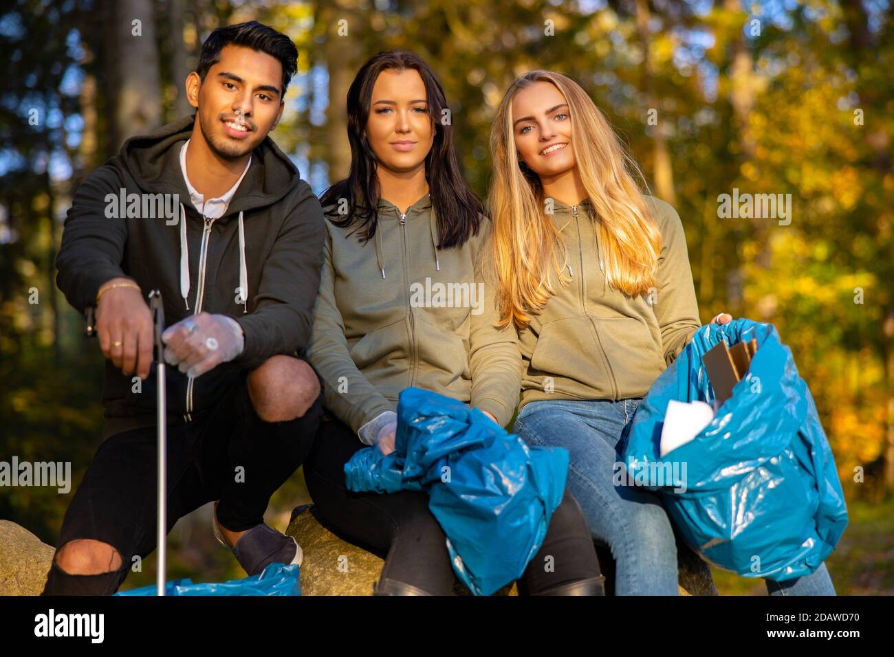Multi-ethnic volunteers in environmental protection team sitting with ...