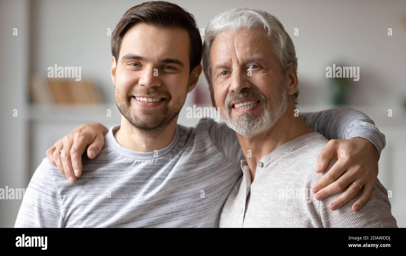 Head shot portrait smiling young man with mature father hugging Stock ...
