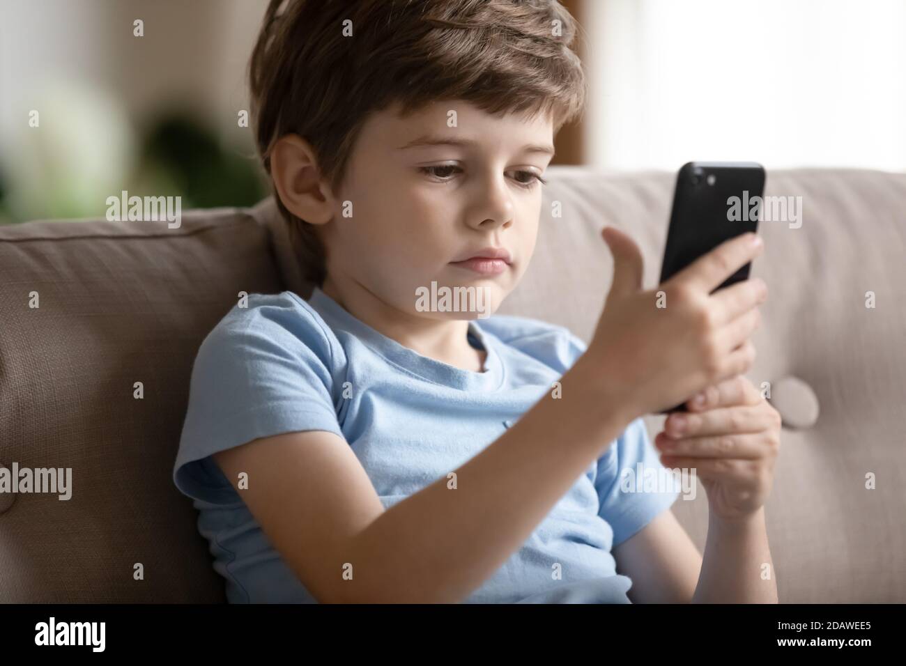 Kid boy child using phone sofa hi-res stock photography and images - Alamy