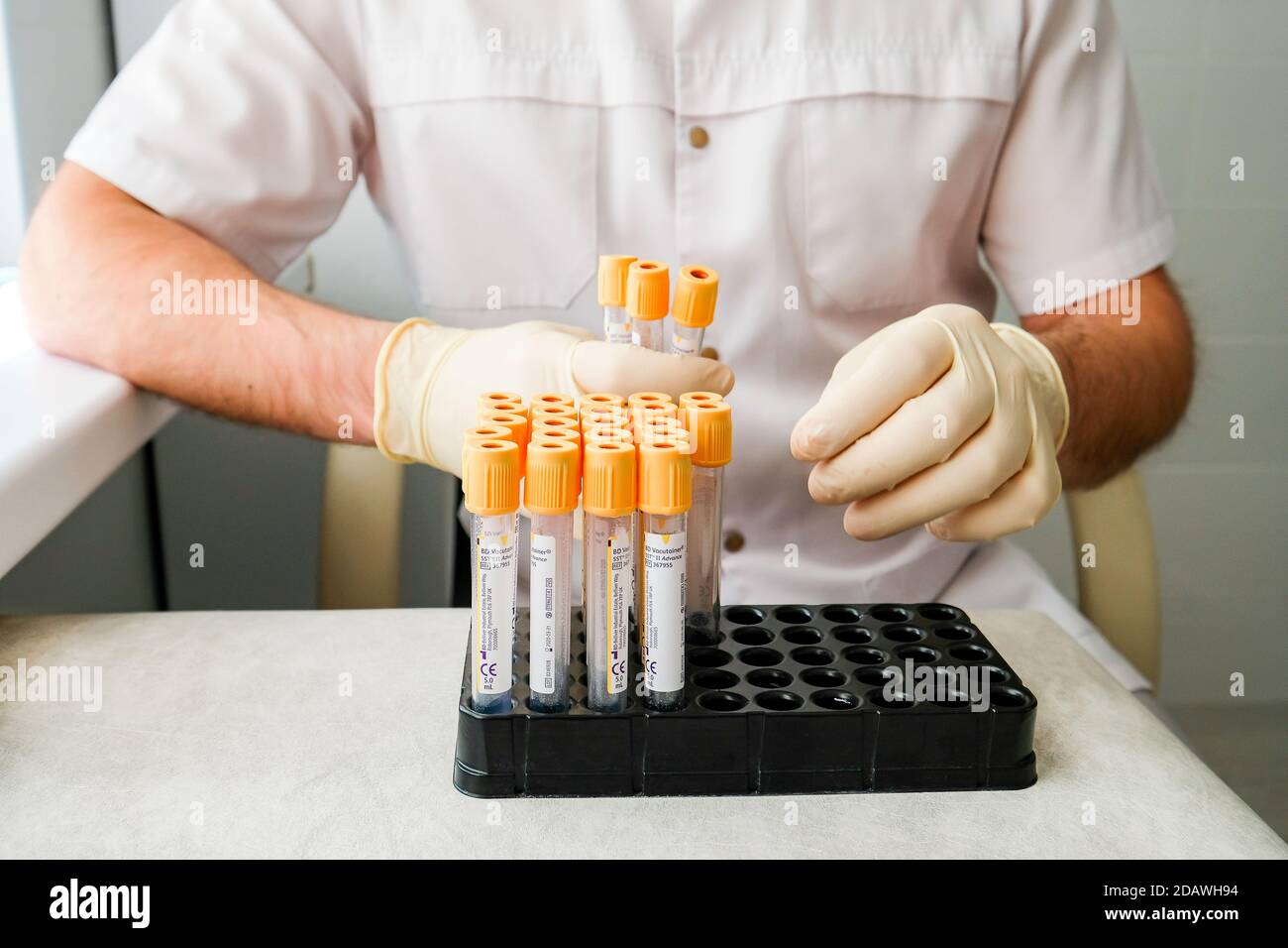 Medical vacuum tubes with colored caps in a stand. Nurse work in the ...
