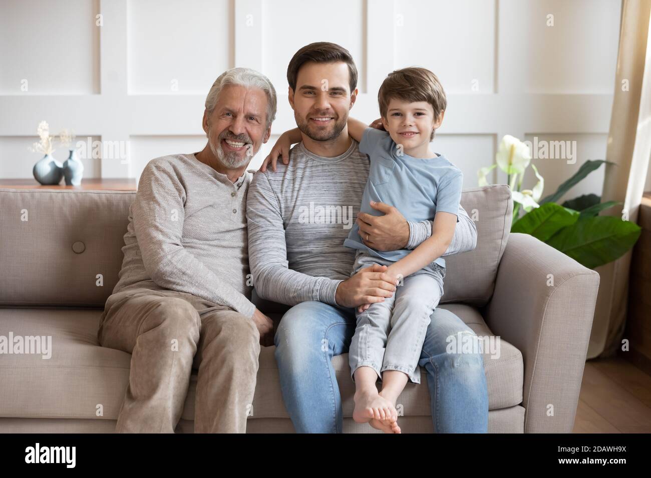 Family portrait happy three generations of men sitting on couch Stock ...