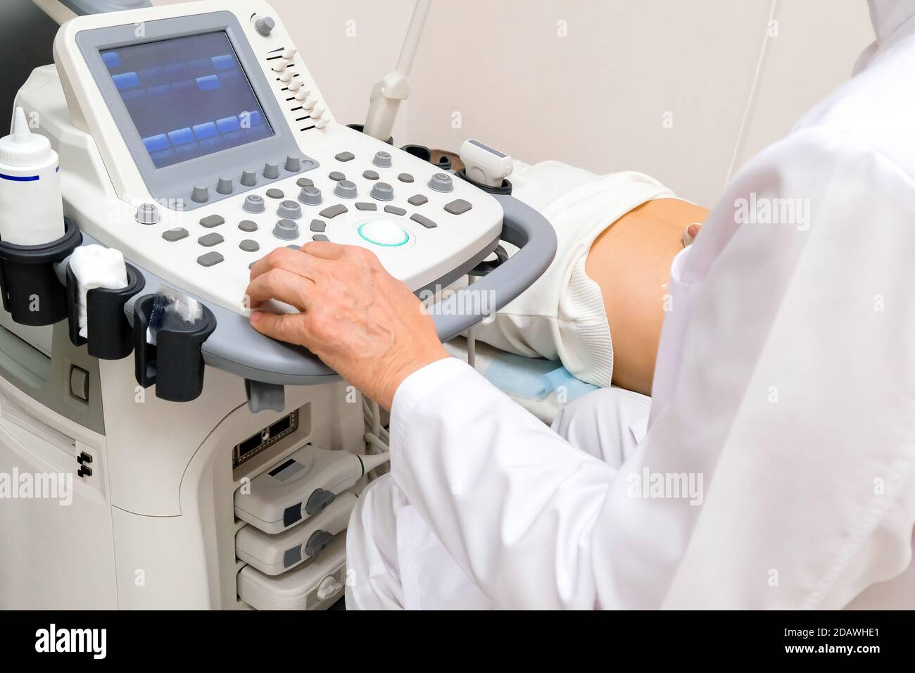 The doctor is sitting at the ultrasound machine. Diagnostic apparatus ...