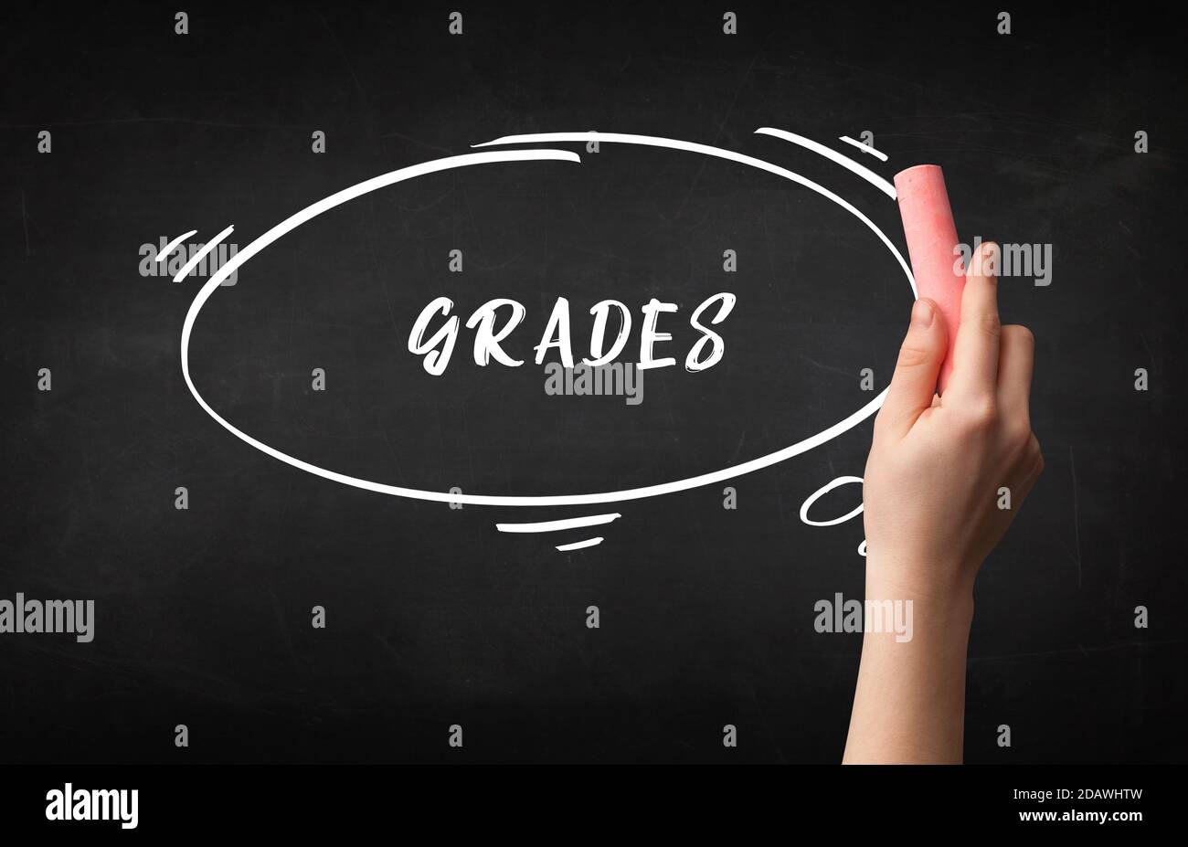 Hand drawing GRADES inscription with white chalk on blackboard ...