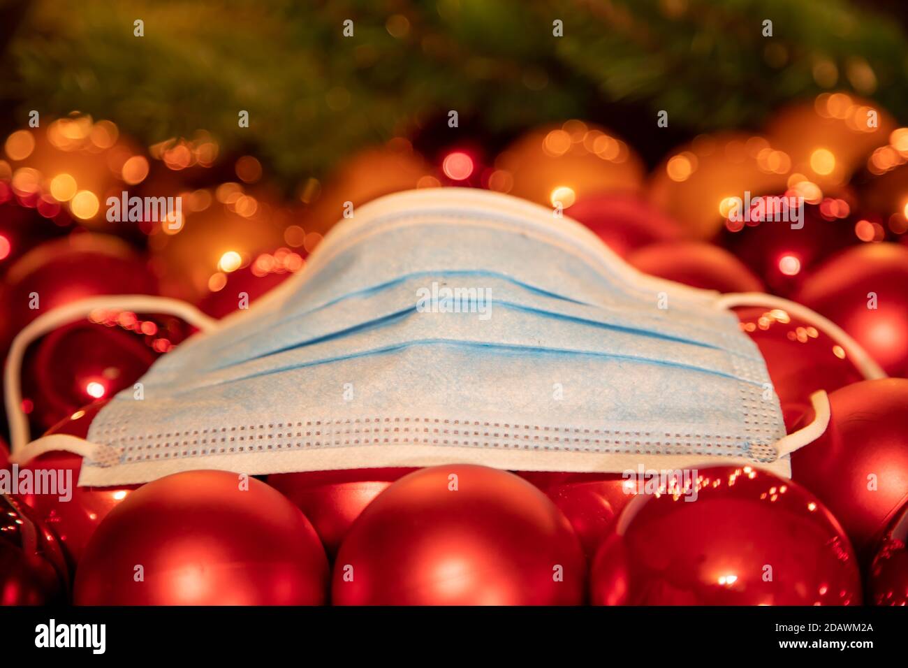 group of red christmas balls and a mouth protection mask, lights in the ...