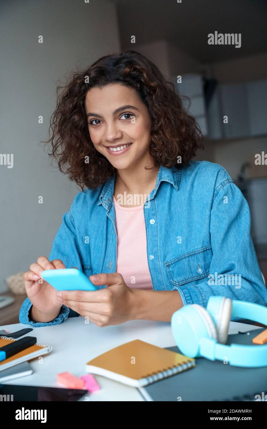 Vertical portrait of young student using smartphone app and looking at ...