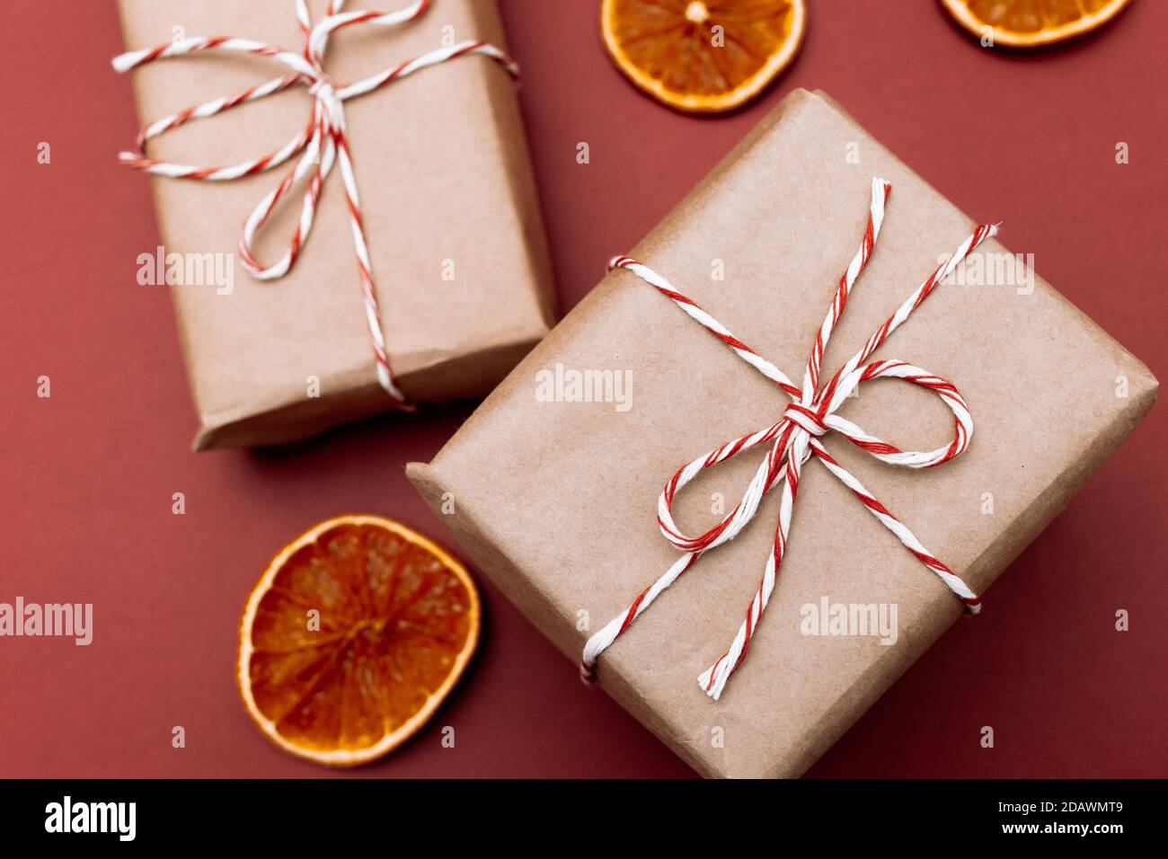 Christmas style rustic brown paper package tied up with strings on red ...