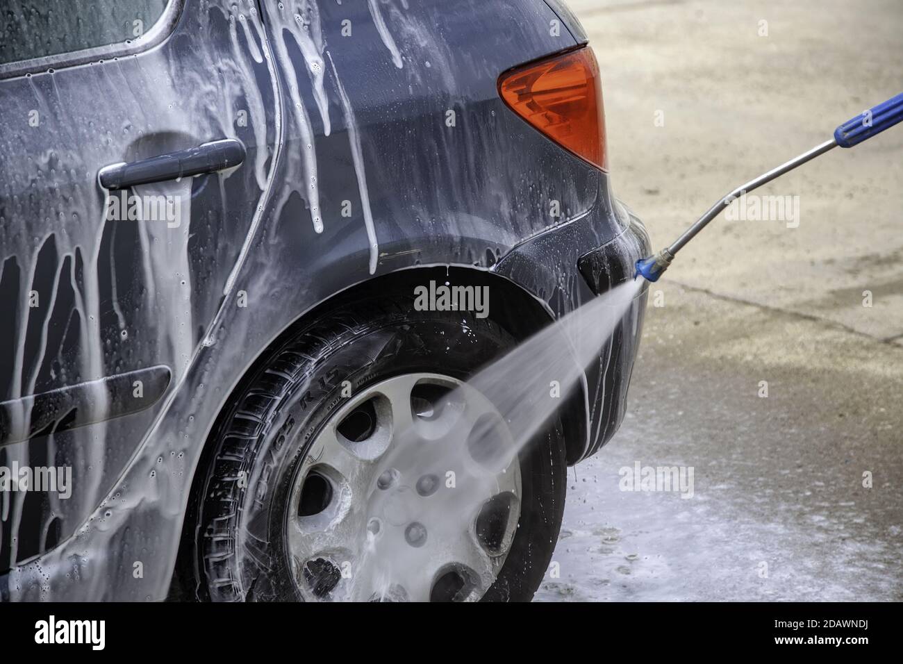Washing car with hose and soap, mechanical workshop, vehicle ...