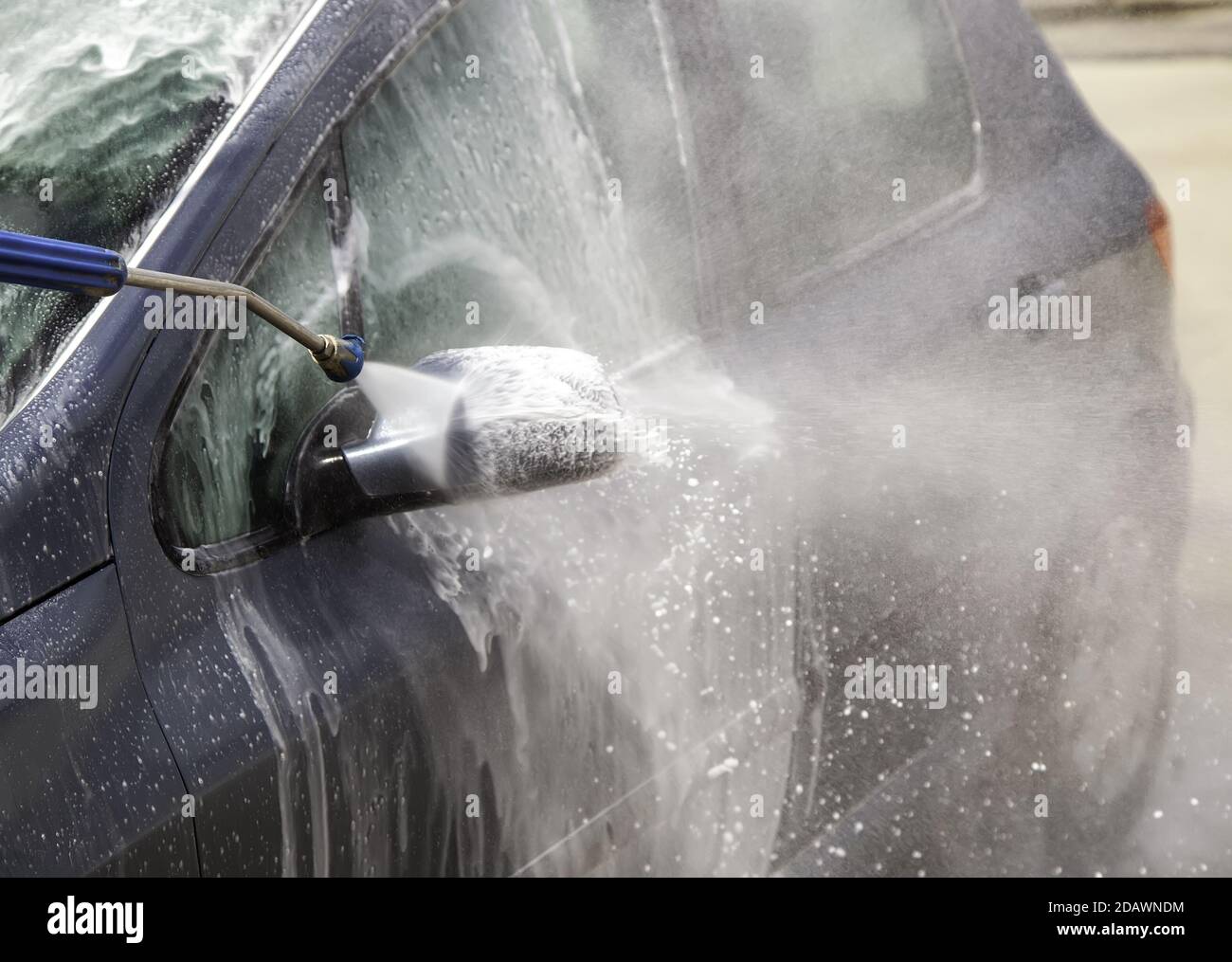 Washing car with hose and soap, mechanical workshop, vehicle ...