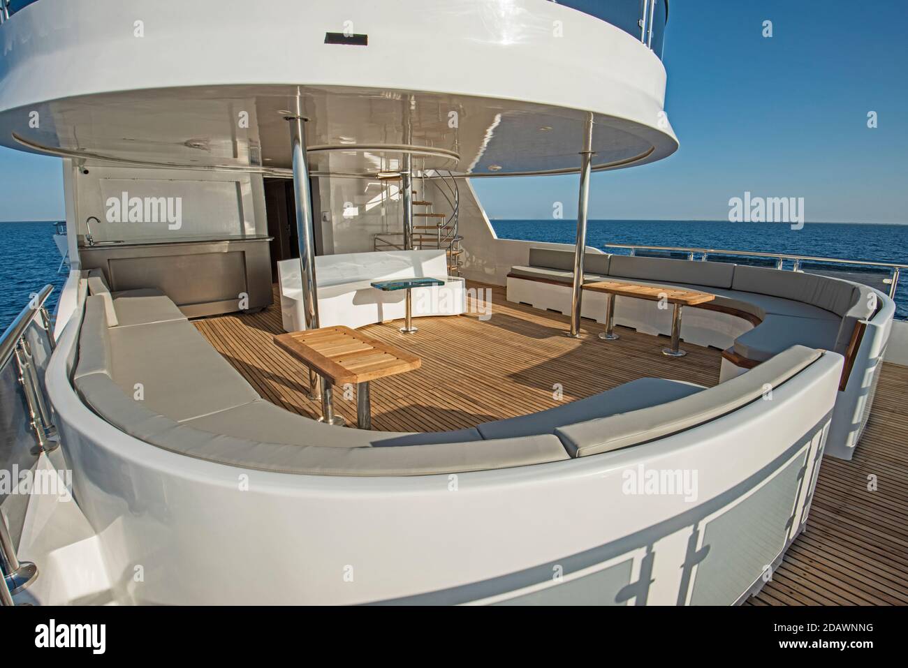 Teak stern wooden deck of a large luxury motor yacht with chairs sofa ...