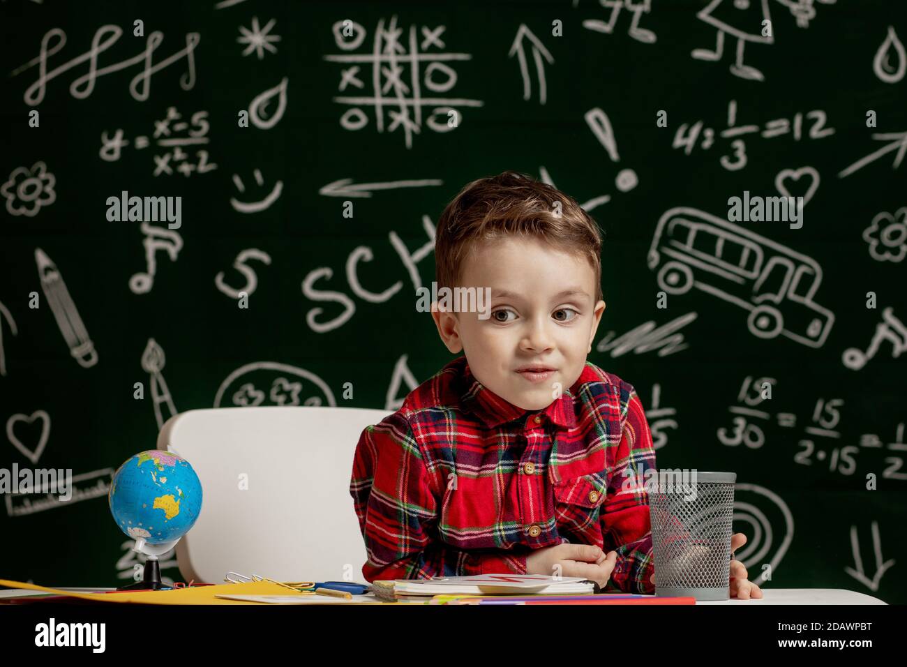 Preschooler boy making school homework. School boy with happy face ...