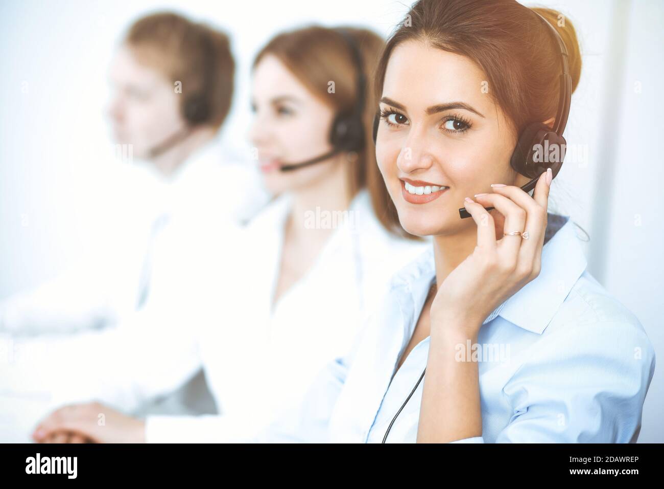 Call center operators. Focus on beautiful business woman in headset Stock Photo - Alamy