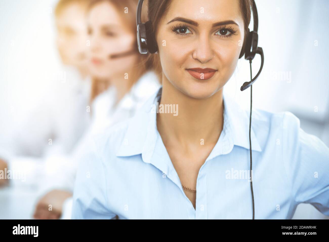 Call center operators. Focus on beautiful business woman in headset Stock Photo - Alamy