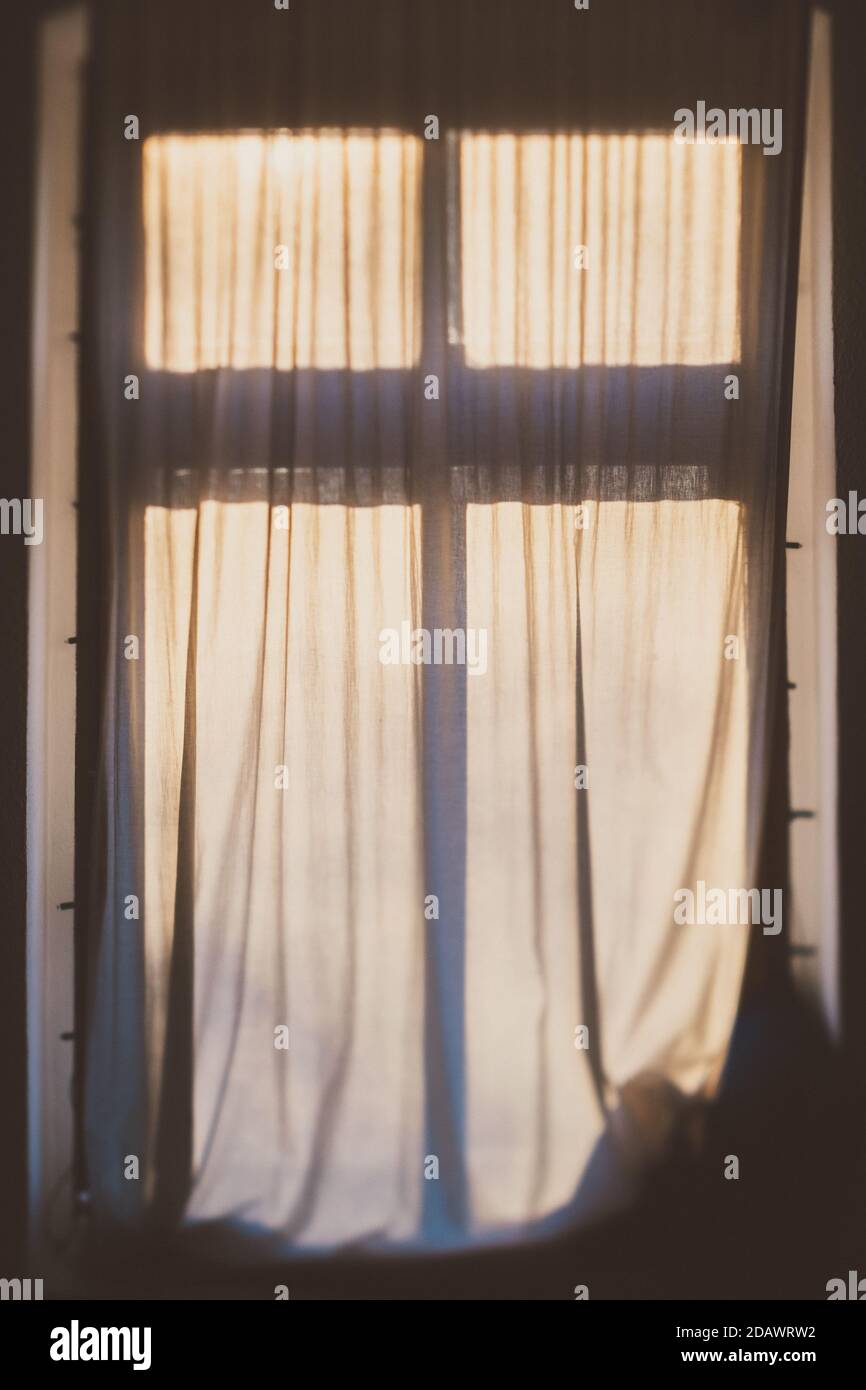 Vertical shot of a closed curtain in front of the window in the morning ...