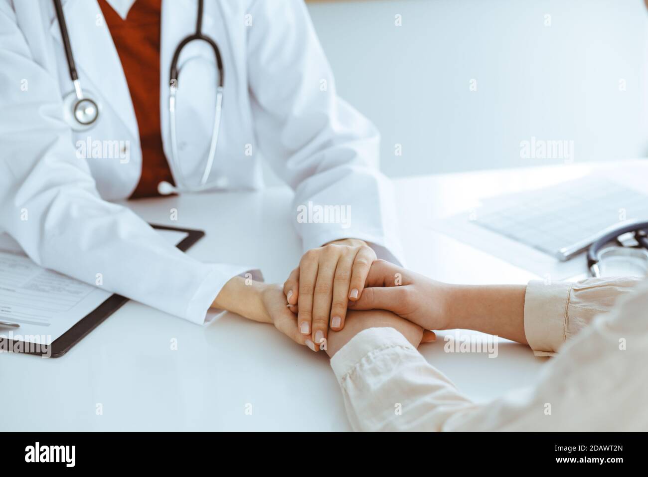 Hands of unknown woman-doctor reassuring her female patient, close-up ...