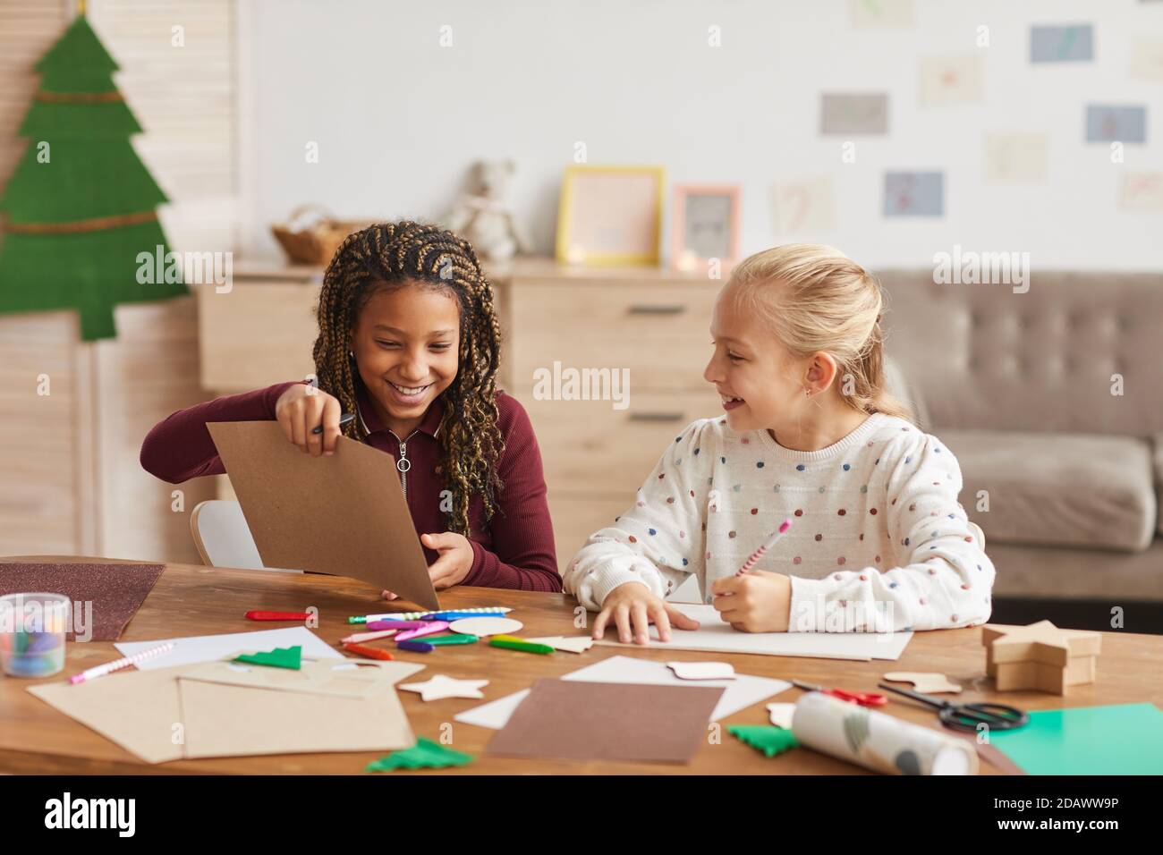 Portrait of two cheerful girls enjoying crafting and painting toether ...