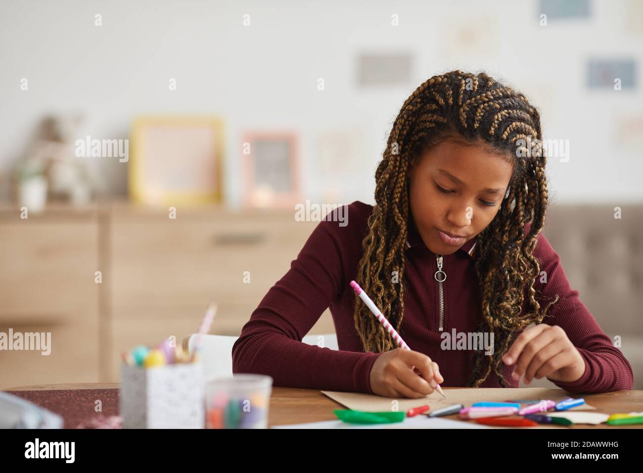 Front view portrait of teenage African-American girl doing homework ...