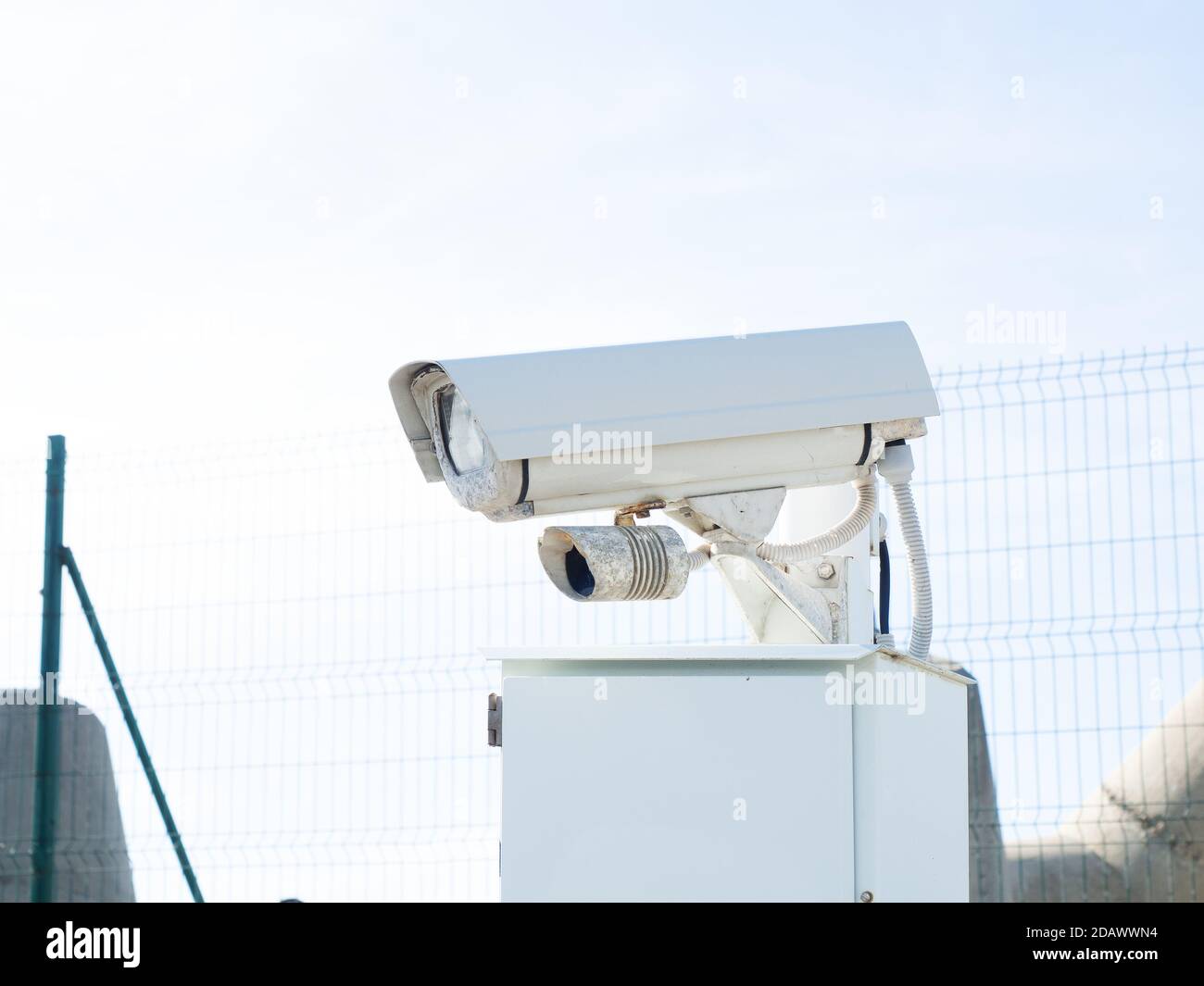 White surveillance camera on a stand outdoors behind a fence Stock ...