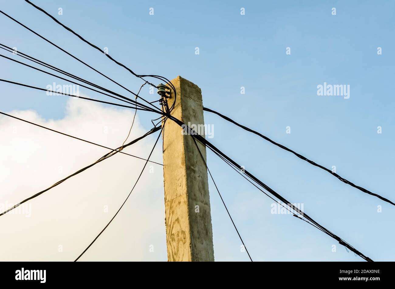 Reaching to the sky is a square utility post with electric power lines ...