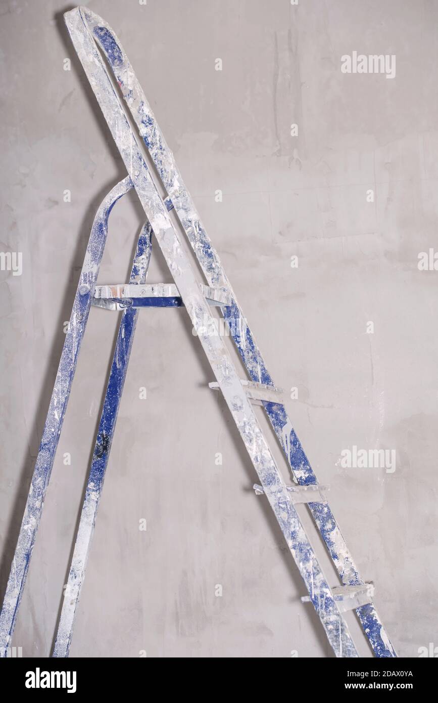 Single blue dirty aluminum folding metal step ladder leaning against ...