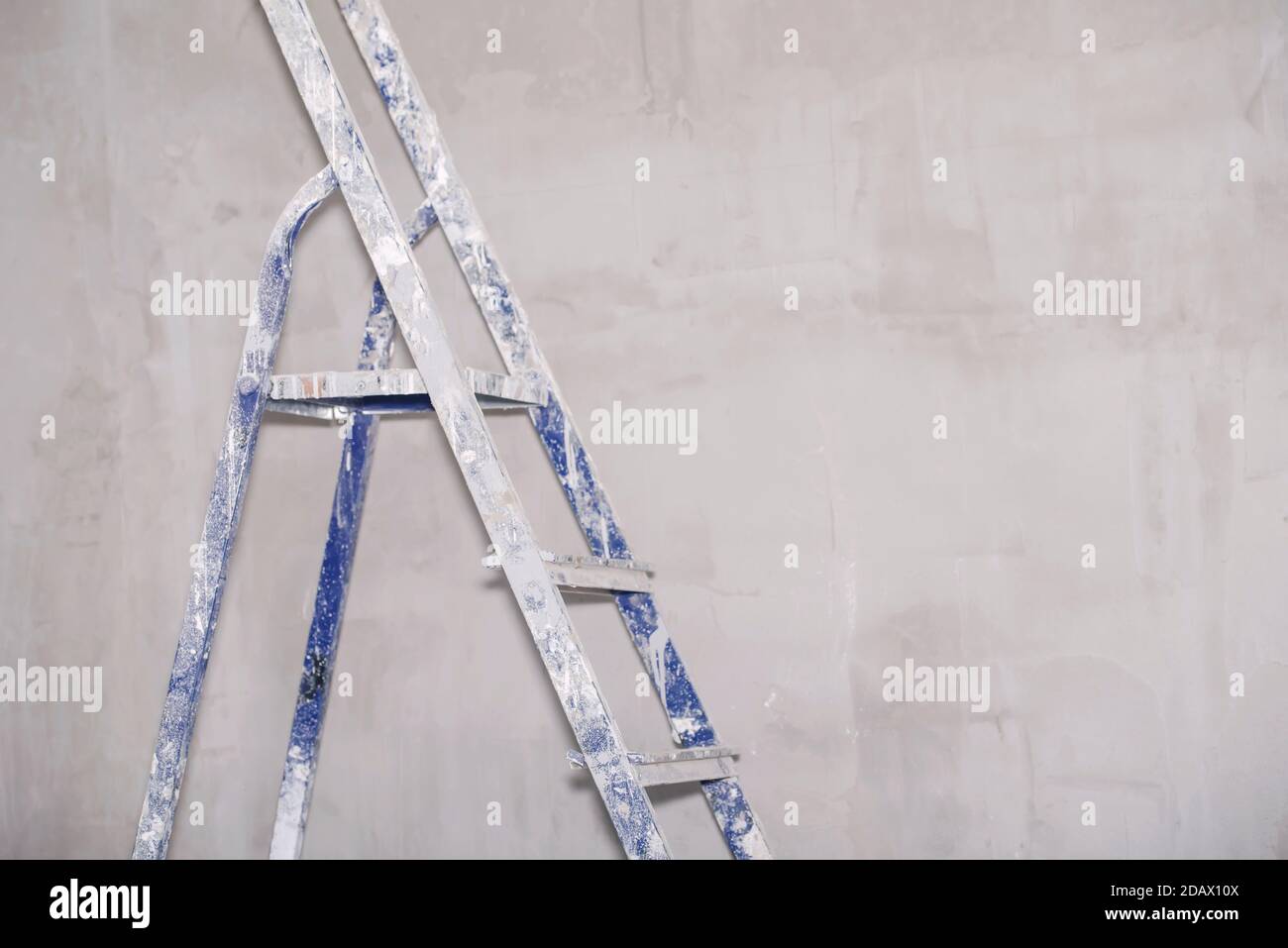 Single blue dirty aluminum folding metal step ladder leaning against ...