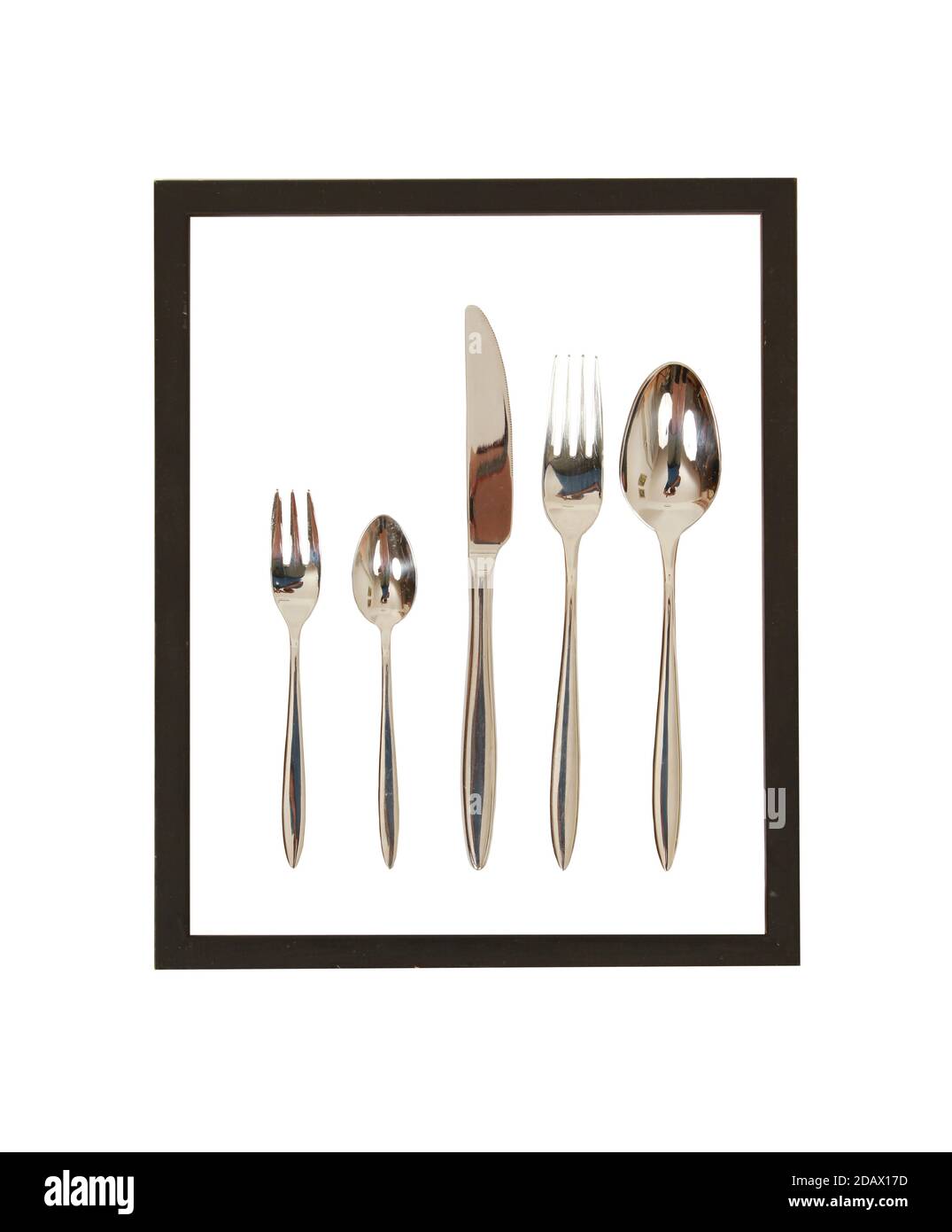 Forks, spoons, and a knife in a frame isolated on a white background ...