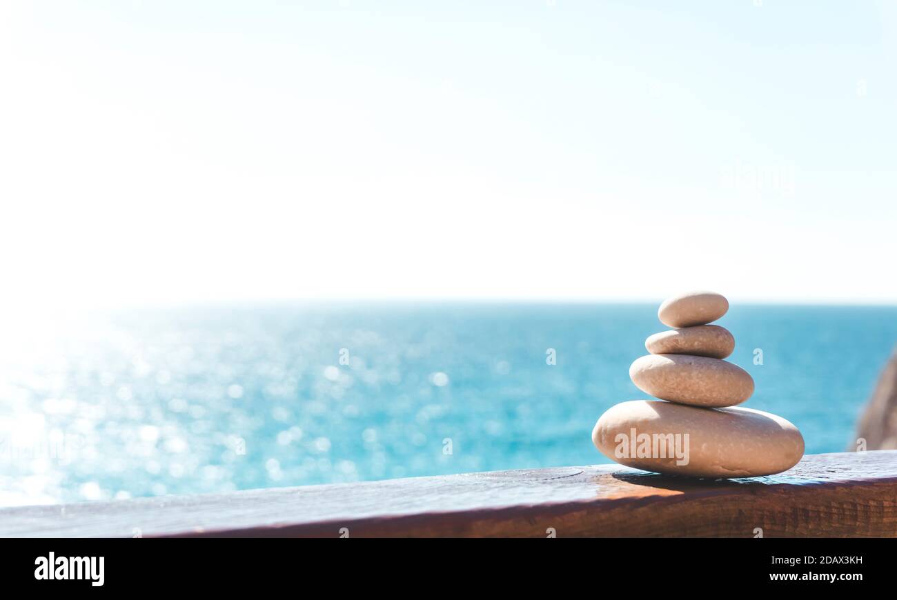 Zen relax background. A pyramid of stones on the beach in clear sunny ...