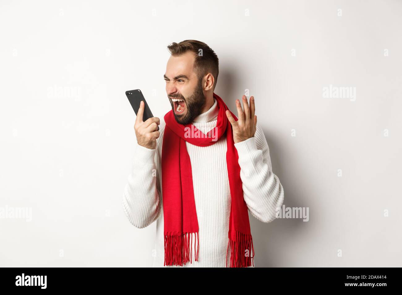 Angry man shouting at smartphone with mad face, standing furious ...