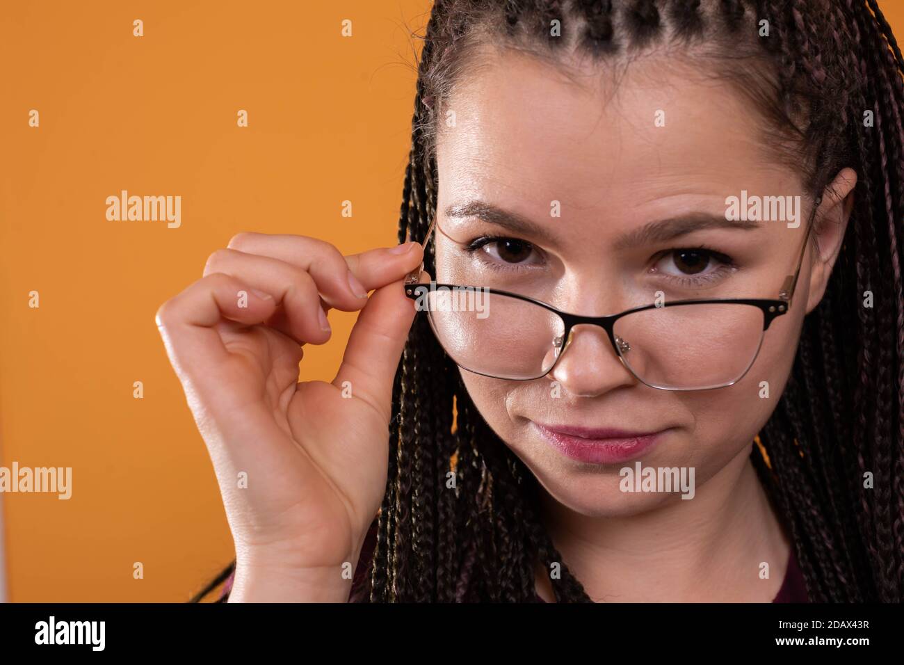 A young adult girl gently adjusts her glasses. Final year student ...