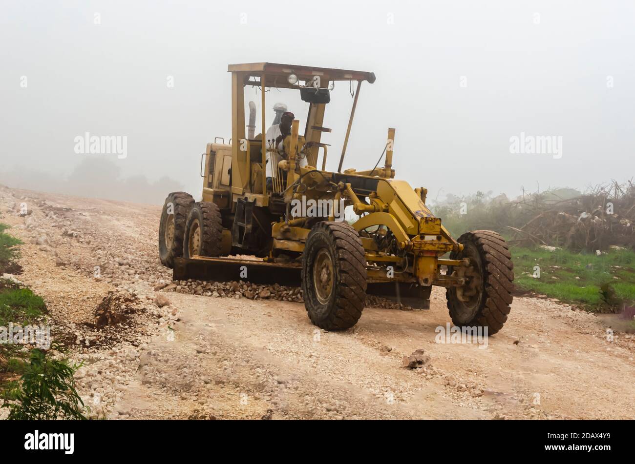 Motor Grader Working On Road On A Fogy Day Stock Photo - Alamy