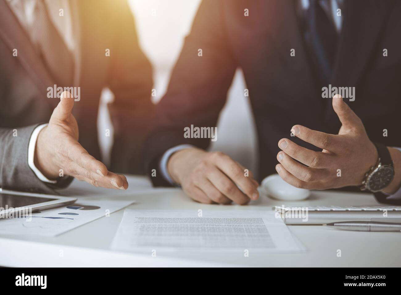Business people using computer while working together in sunny office ...
