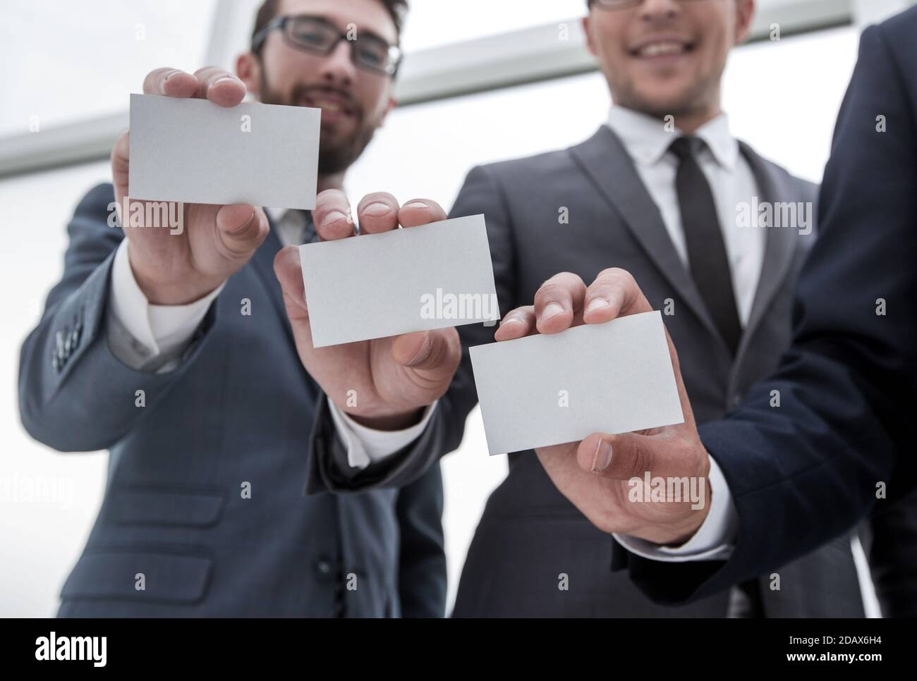 three young business partners showing their business cards Stock Photo ...