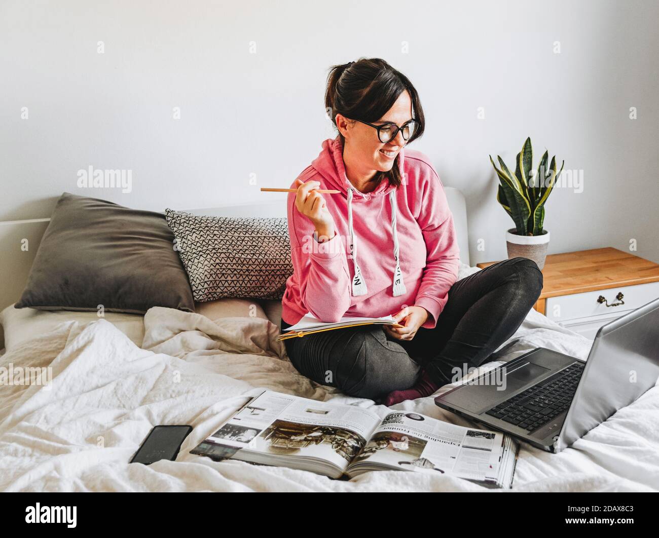 Female doing academic research with a computer and books while sitting ...