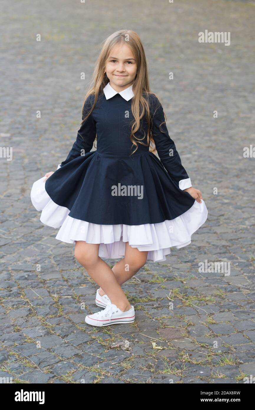 Elegant and classy. Happy child make curtsy in uniform outdoors. Dress ...