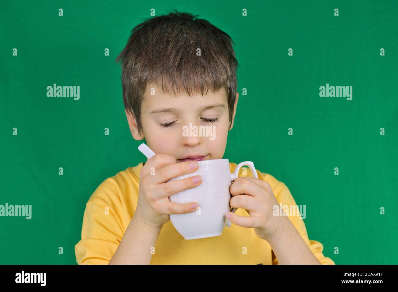 Cute Caucasian child drinking a cup of tea Stock Photo - Alamy
