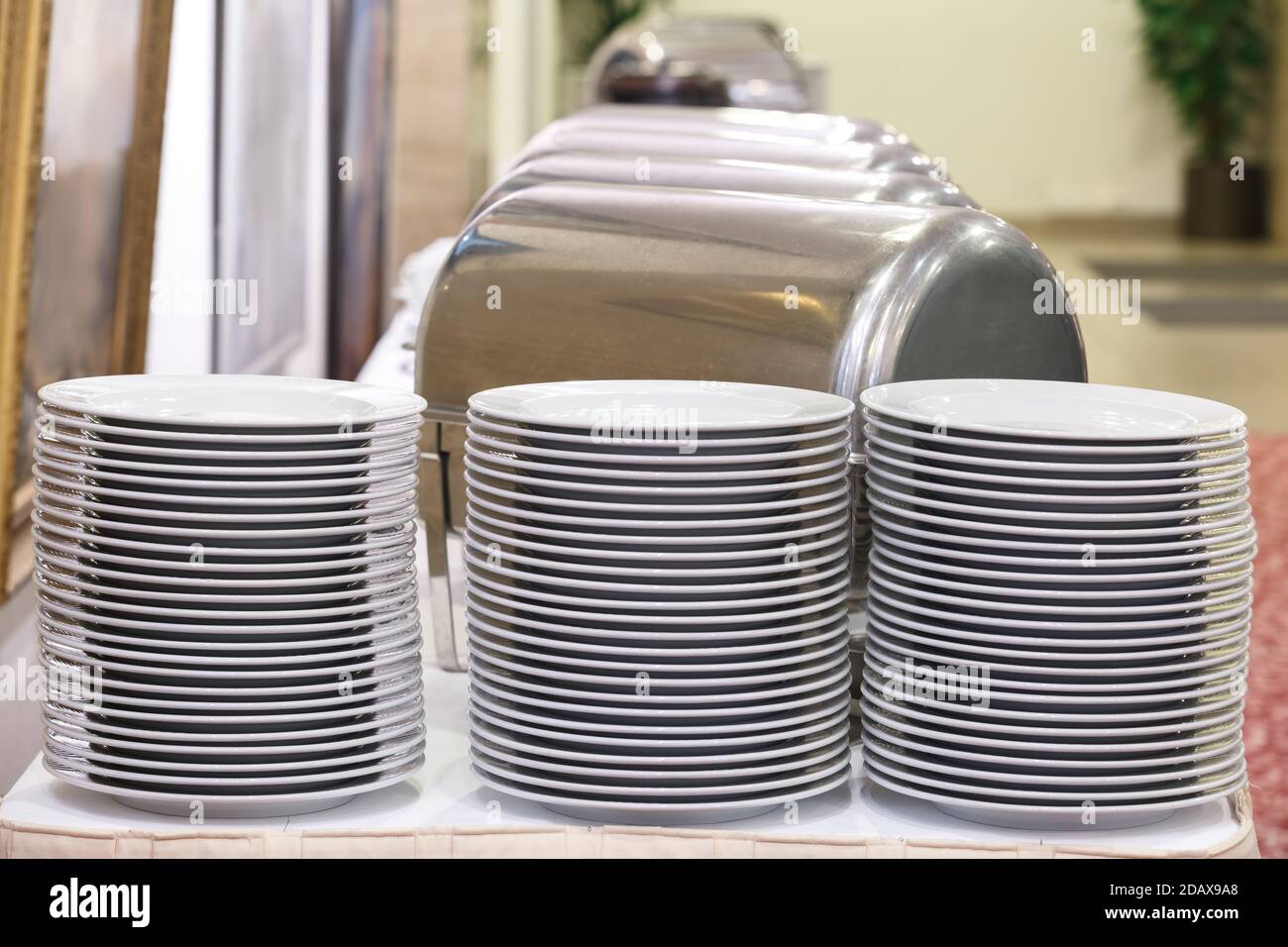 Three stacks of clean plates on the table close up Stock Photo - Alamy