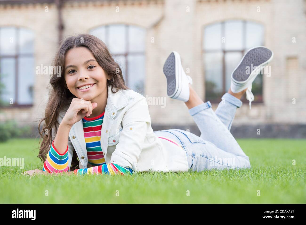 Feel free and safe. Happy child relax on green grass. Beauty look of ...