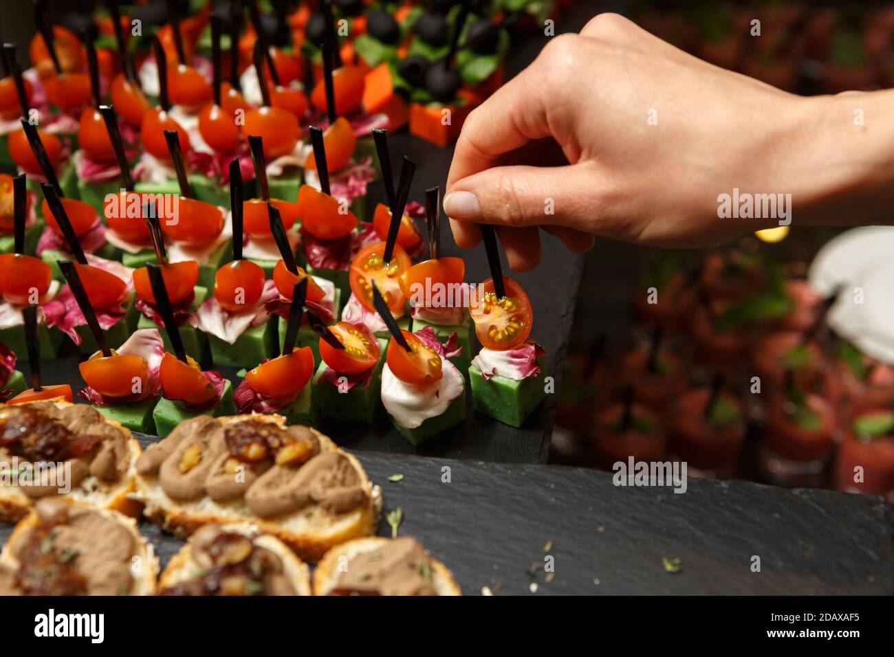 Hand takes vegetable canape from tray closeup Stock Photo - Alamy