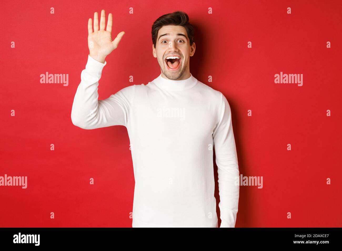 Image of happy and friendly young man saying hello, waving hand to ...